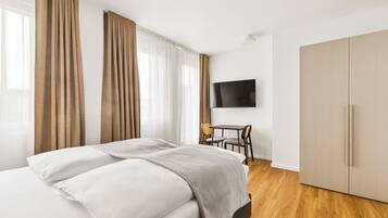 Quarto com cama, escrivaninha, cadeira e guarda-roupa.