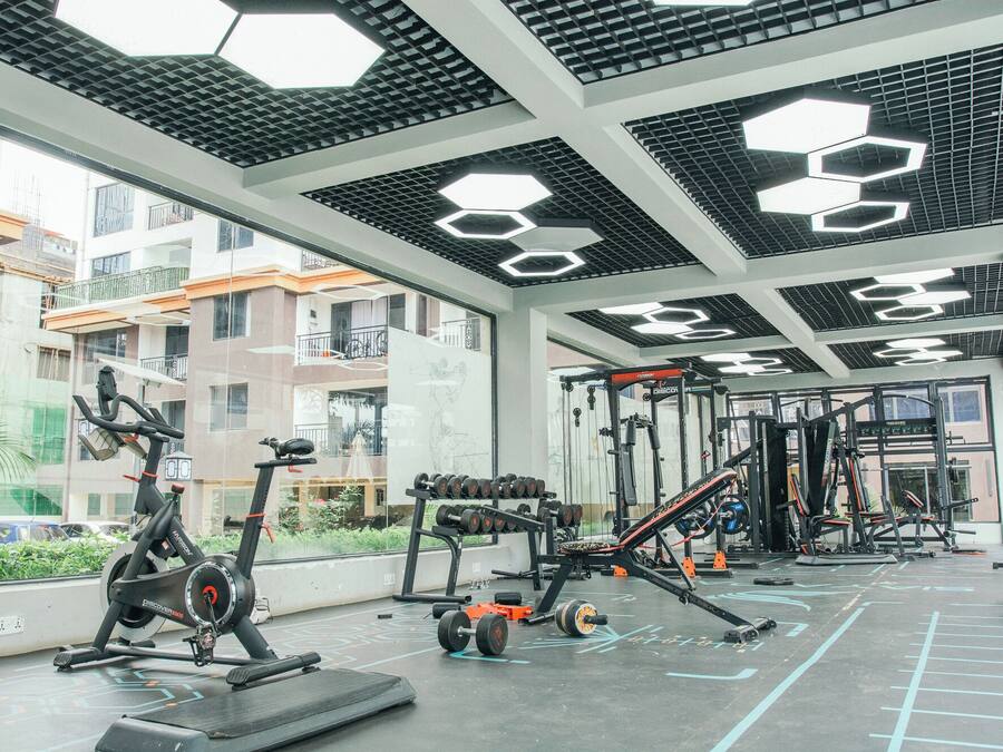 Academia com equipamentos de ginástica, incluindo esteiras, halteres e aparelhos de musculação.