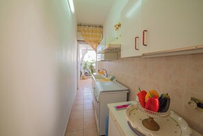 Um frigorífico, um forno, uma placa de cozinha, uma cafeteira/bule 