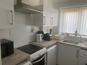 Um frigorífico, um micro-ondas, um forno, uma placa de cozinha