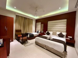 Quarto de hotel com duas camas, uma escrivaninha, uma cadeira e um guarda-roupa.