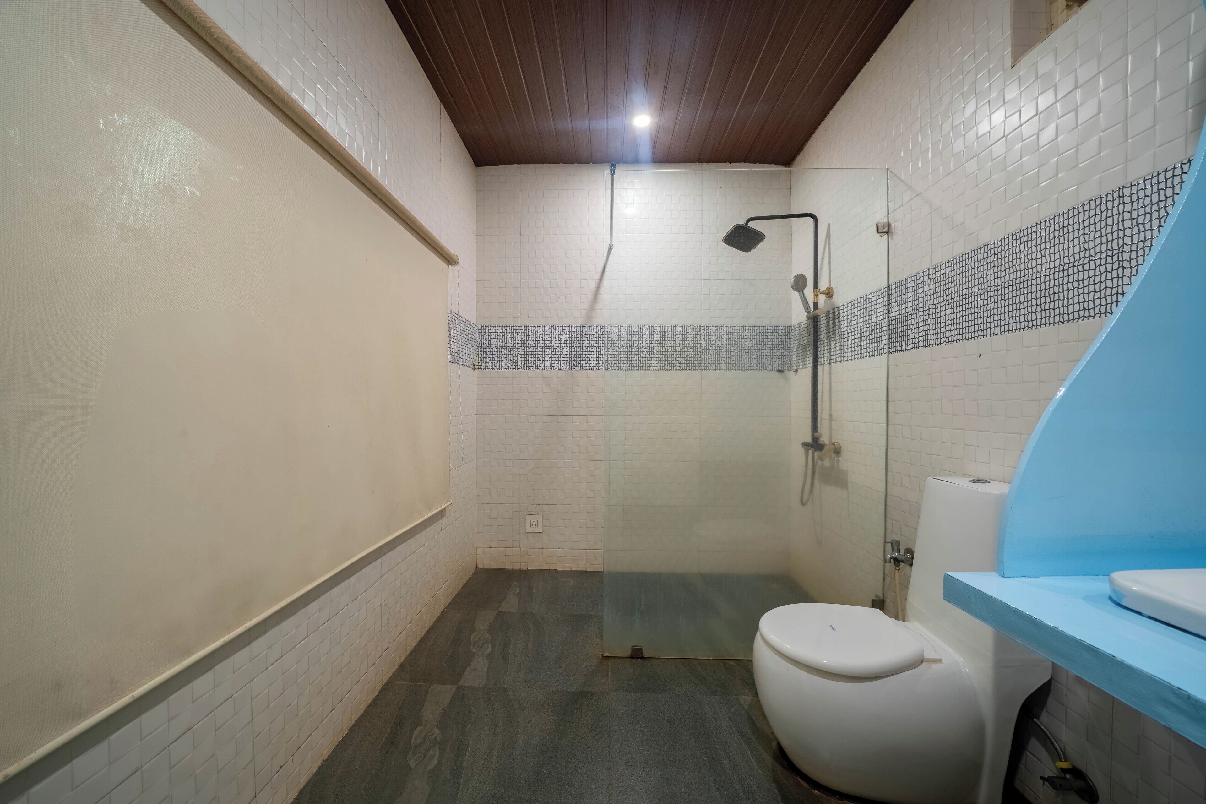 Casa de banho com sanita, chuveiro e lavatório.