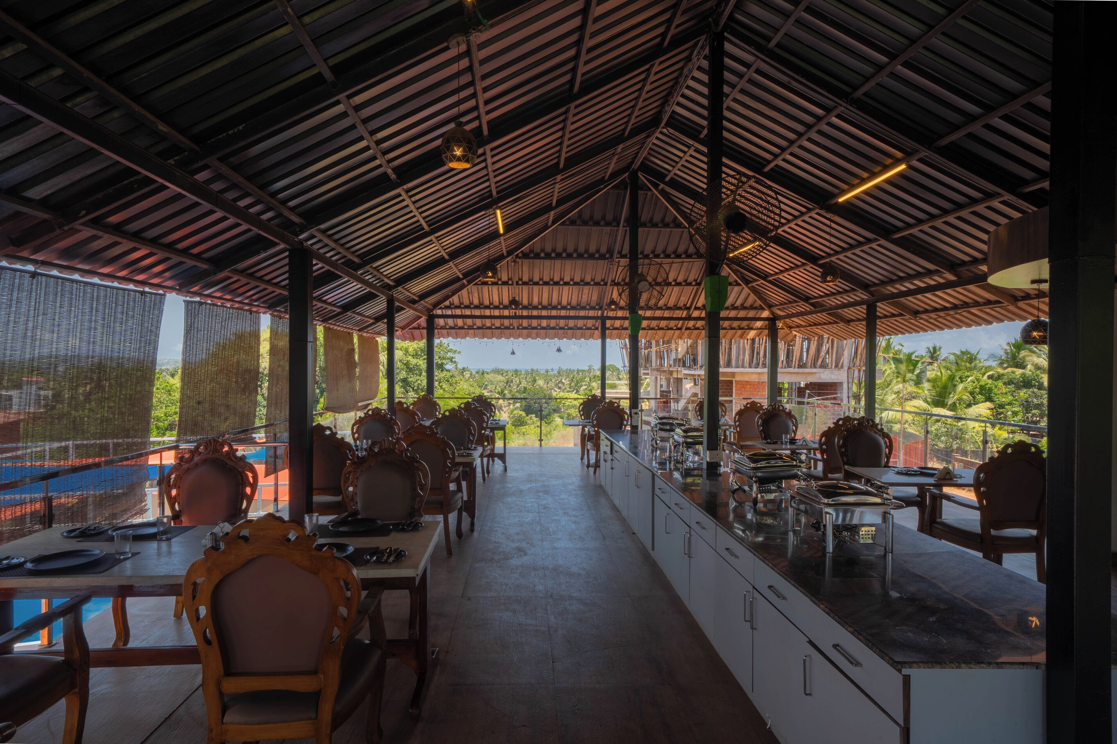 Uma sala de jantar ampla com pé direito alto e grandes janelas com vista para uma paisagem deslumbrante.