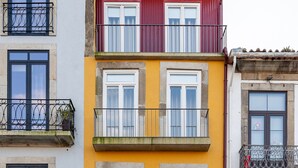 Um edifício com vários andares, varandas, uma loja e um letreiro de restaurante.
