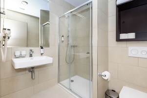 Um secador de cabelo, toalhas fornecidas, sabão, champô 