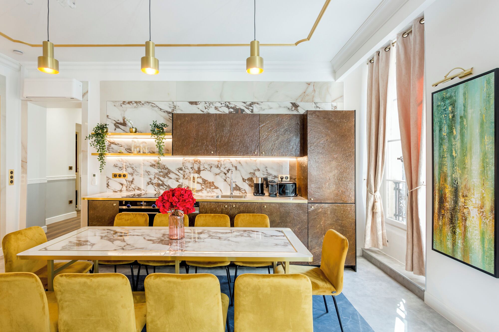 Cozinha moderna com bancadas de mármore, uma ilha central e cadeiras amarelas.