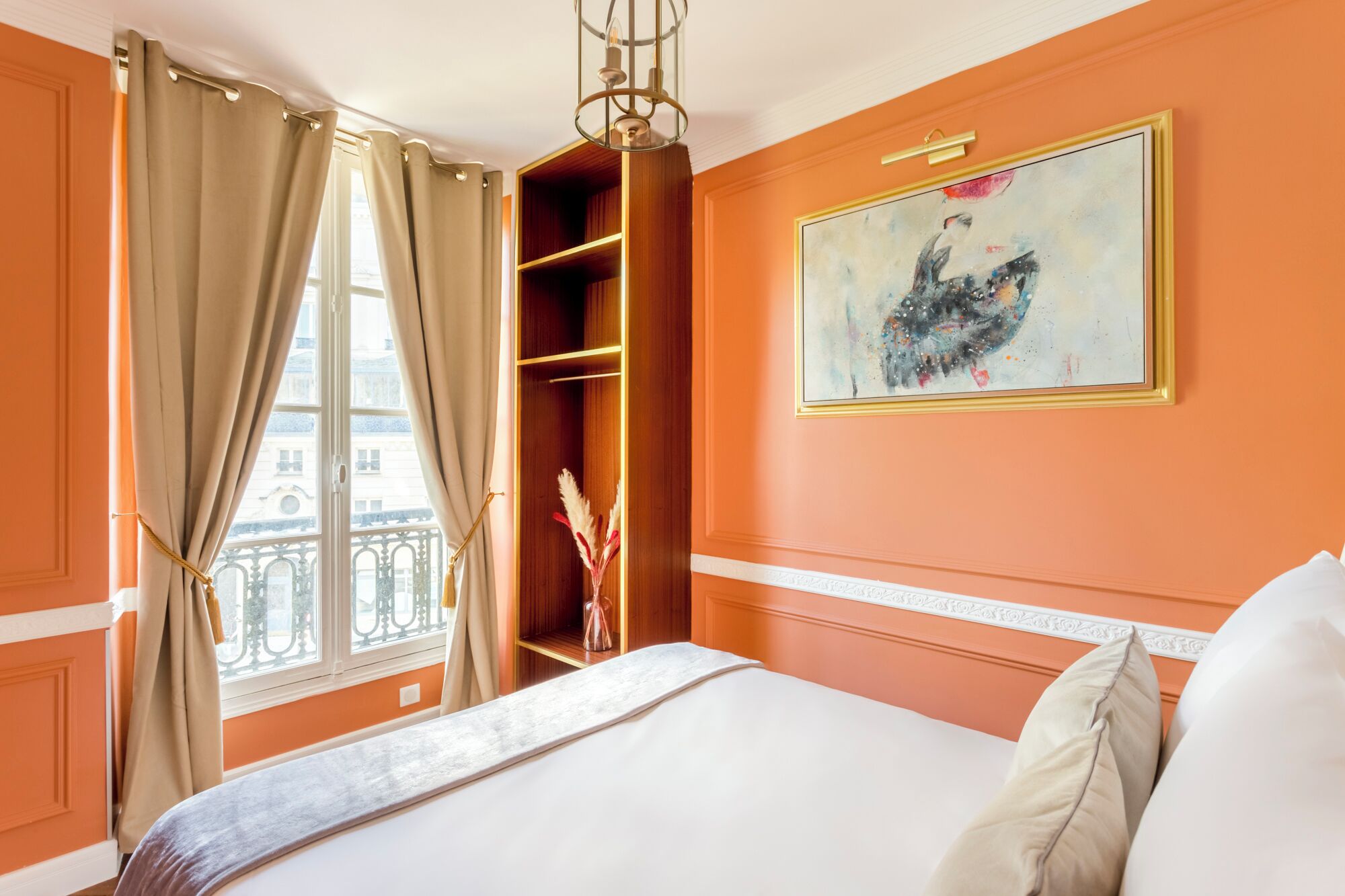 Quarto de hotel com uma cama, um quadro e vista para uma varanda.