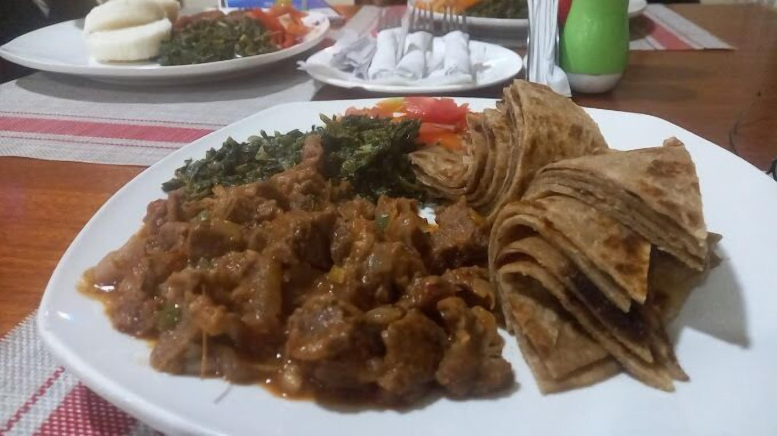 Um prato com carne, vegetais e pão sírio.