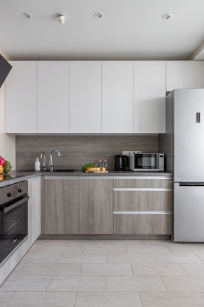 Apartamento, ar condicionado, Vista para a cidade | Cozinha privada | Um frigorífico, um micro-ondas, um forno, uma placa de cozinha