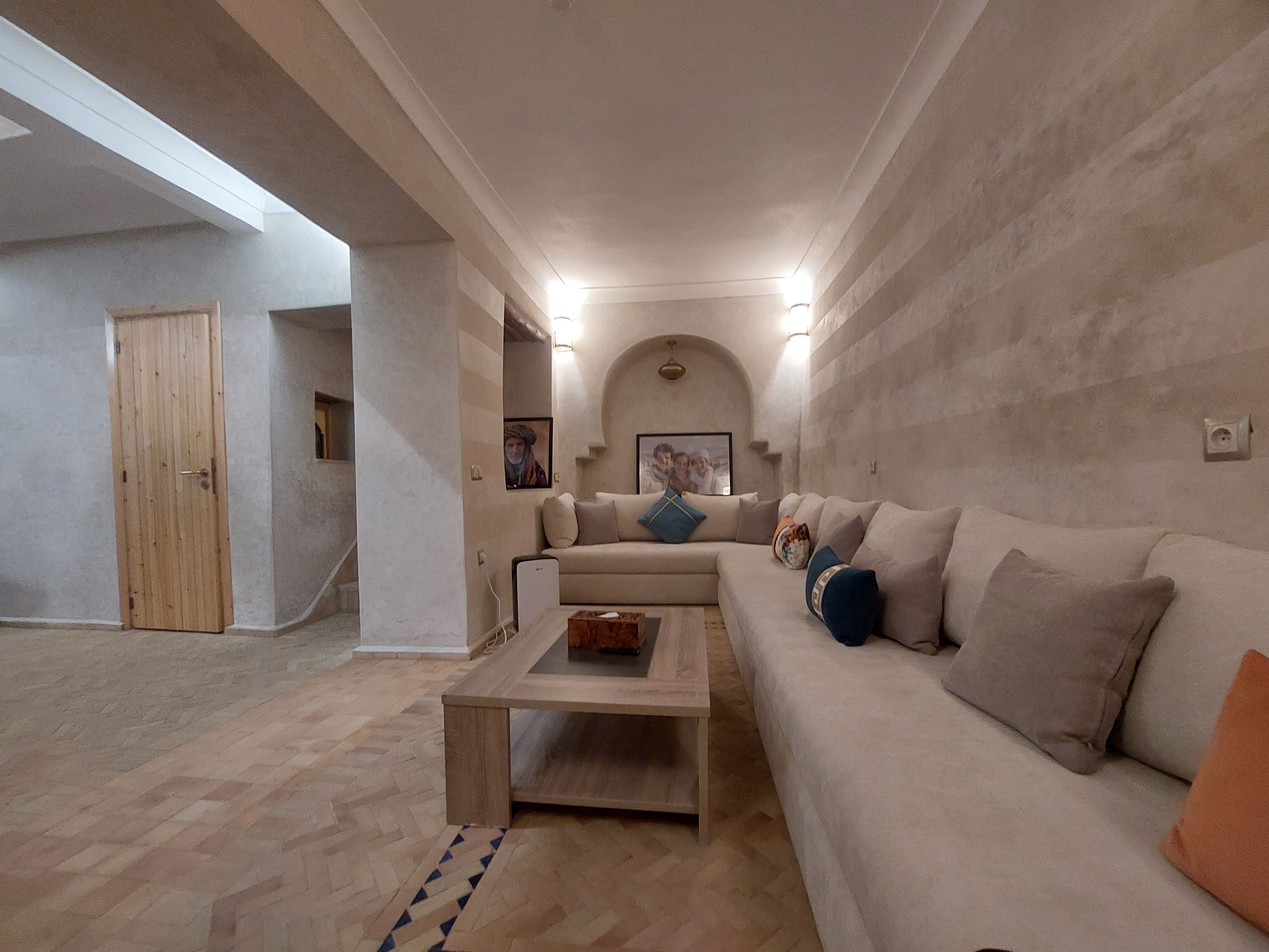 Uma sala de estar com sofá, mesa de centro e uma porta.