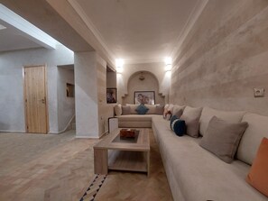 Uma sala de estar com sofá, mesa de centro e uma porta.