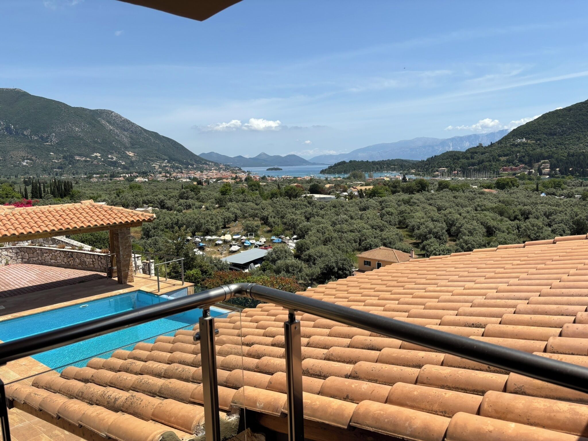 Uma área de piscina com vista para uma cidade costeira e montanhas.