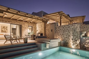 Fachada de pedra com piscina, área de estar ao ar livre e um terraço coberto.