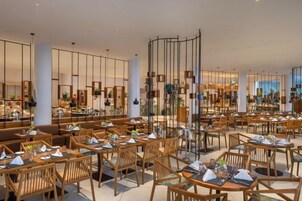 Um restaurante espaçoso com mobiliário de madeira e design de interiores moderno.