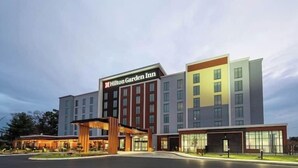 Um Hilton Garden Inn com design moderno, apresentando uma entrada destacada e vários andares.