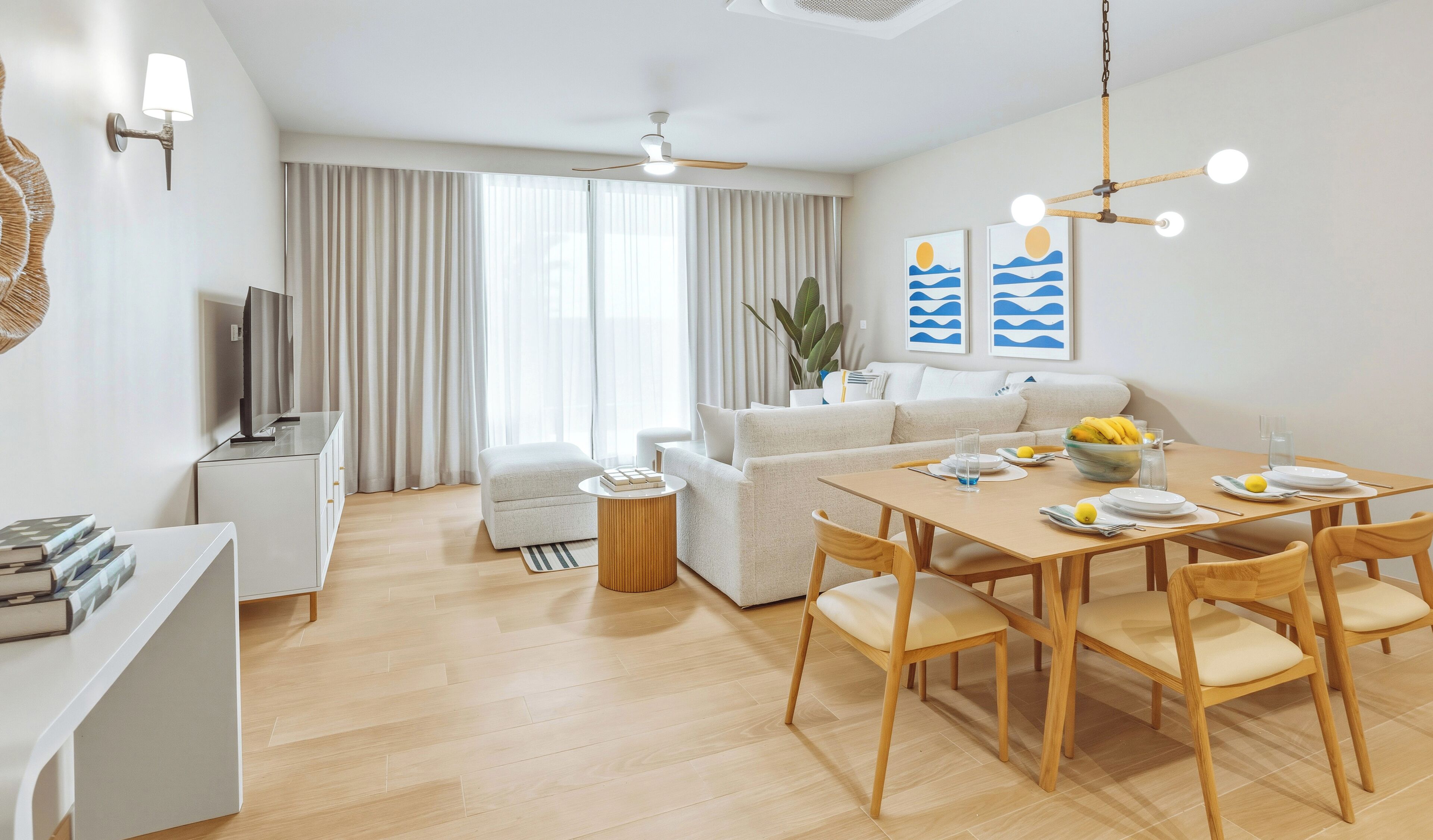 Uma sala de estar moderna com área de jantar, televisão e ventilador de teto.