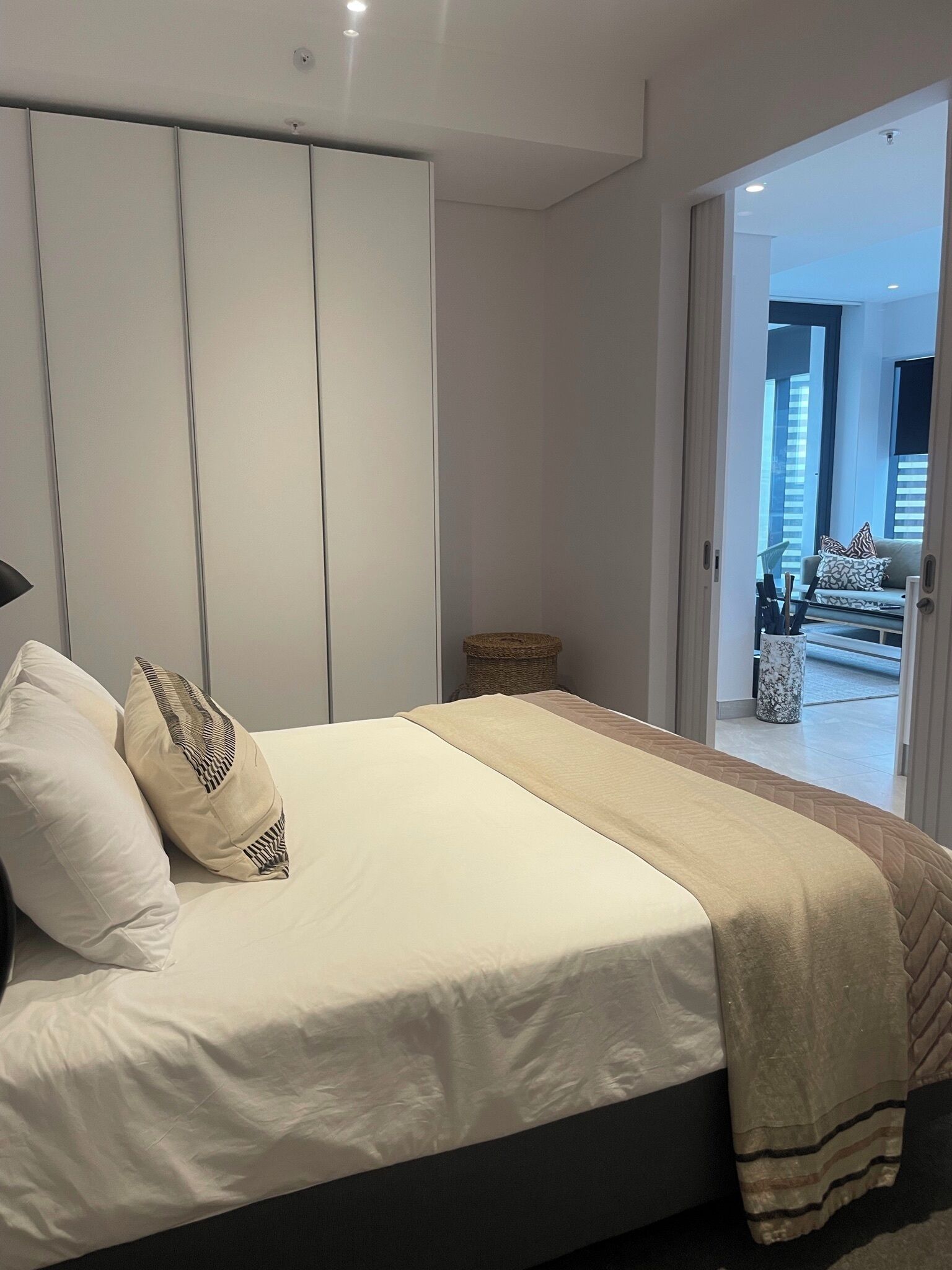 Quarto com cama, guarda-roupa e vista para uma varanda.