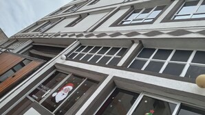 Um edifício com várias janelas, algumas decoradas com motivos natalícios.