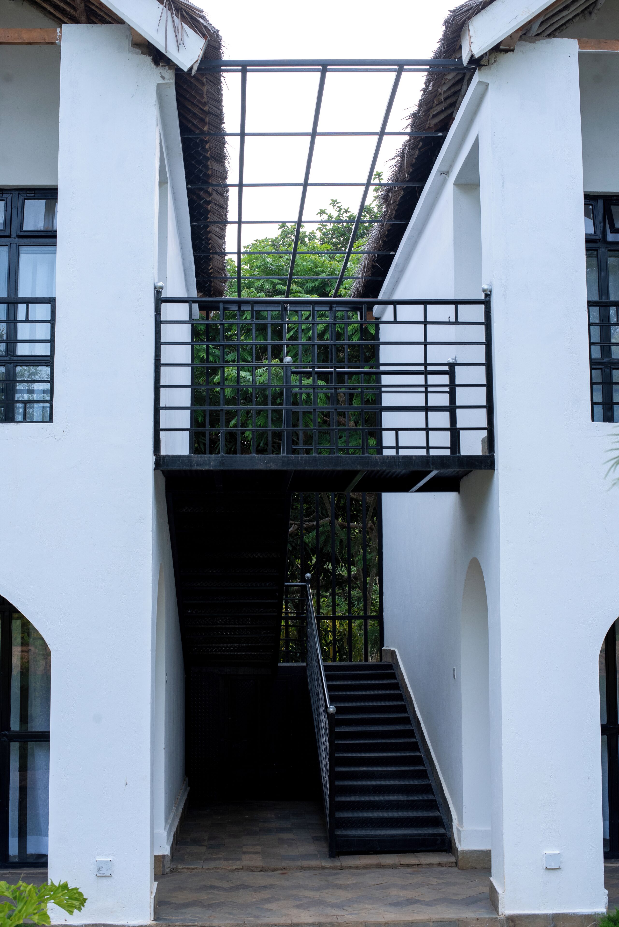 Um edifício branco com uma escadaria que leva a uma varanda.