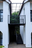 Um edifício branco com uma escadaria que leva a uma varanda.