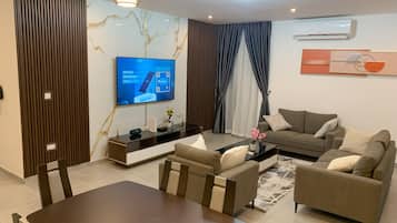 Apartamento família | Área de estar | Smart TV 65 polegadas com canais via satélite