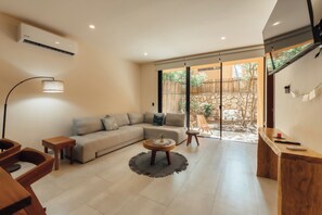 Apartamento superluxo, várias camas, varanda, vista para o jardim | Área de estar | TV de tela plana 50 polegadas com canais digitais
