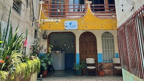 Um edifício de dois andares com placa de centro médico, janelas em arco e uma varanda.