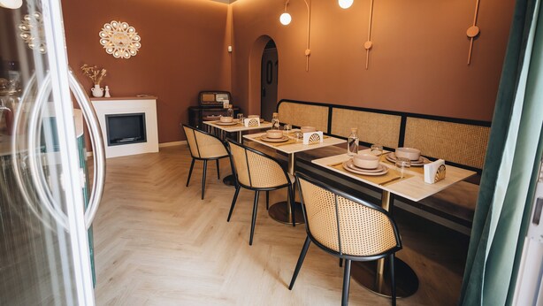 Uma sala de jantar com uma mesa grande, cadeiras e lareira.