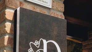 Placa com o nome e o logotipo da pousada Presentosa Bed and Breakfast.