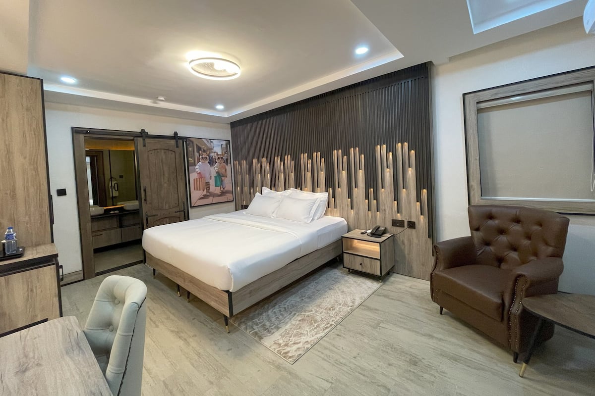 Quarto moderno com uma cama grande, uma escrivaninha, uma cadeira e um guarda-roupa.