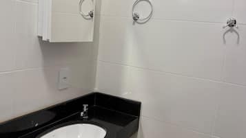 Quarto triplo básico, varanda coberta, vista para o pátio | Banheiro | Chuveiro, toalhas de banho, papel higiênico