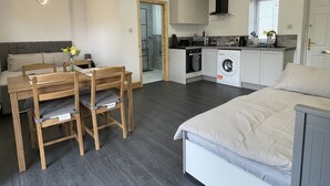 Um apartamento compacto e moderno, com cozinha compacta, área de refeições e um quarto.