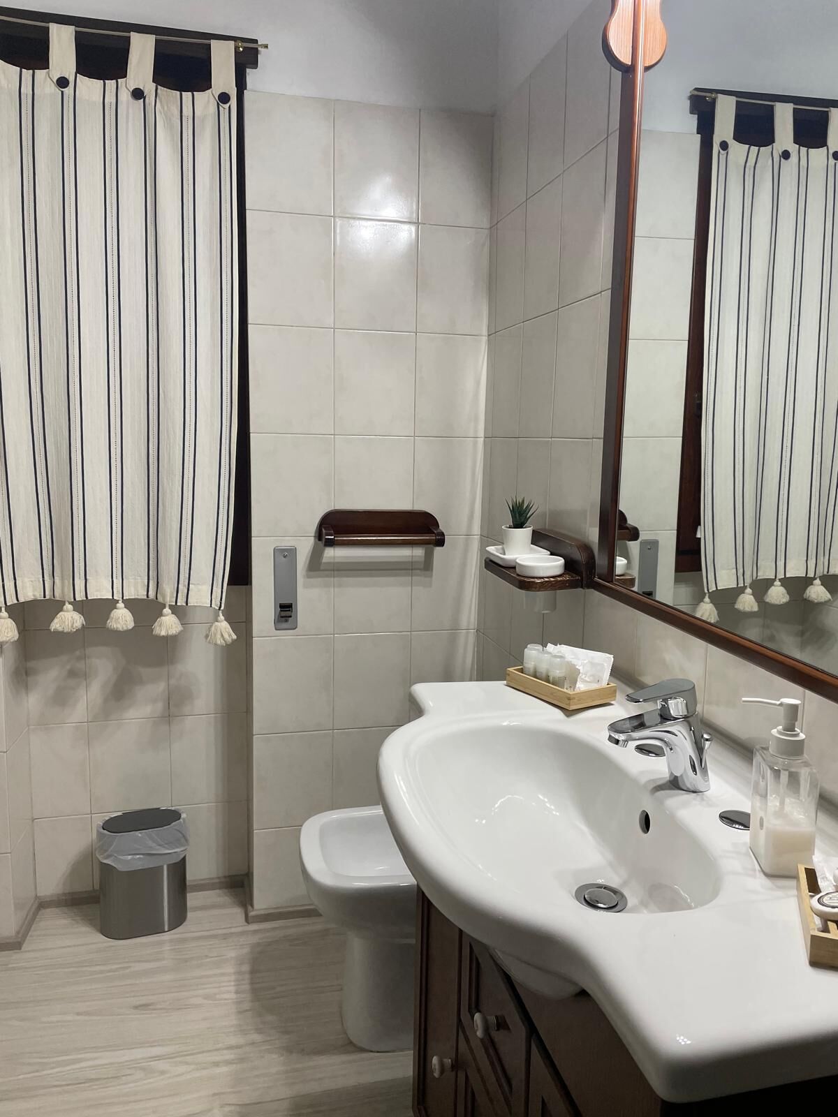 Um banheiro moderno com pia branca, espelho e vaso sanitário.