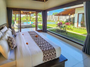 Um quarto espaçoso com uma cama grande, vista para uma piscina e um jardim bem cuidado.