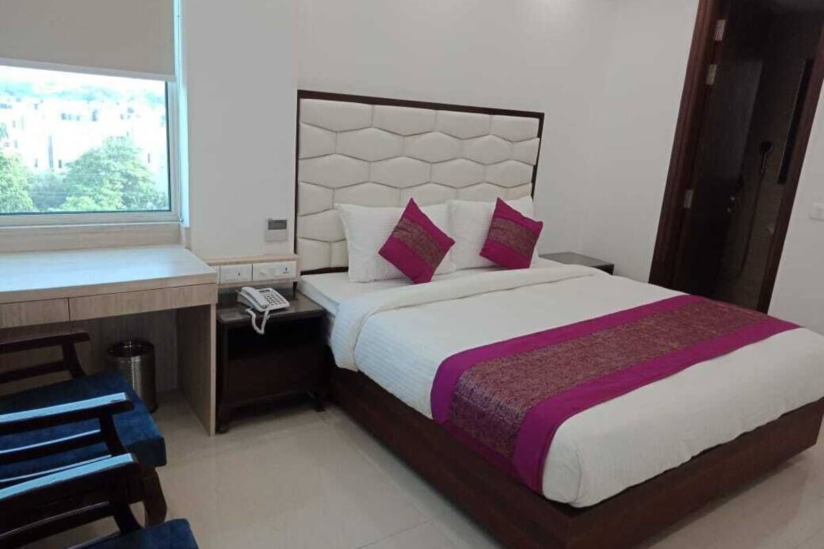 Um quarto com uma cama, uma escrivaninha e uma cadeira.