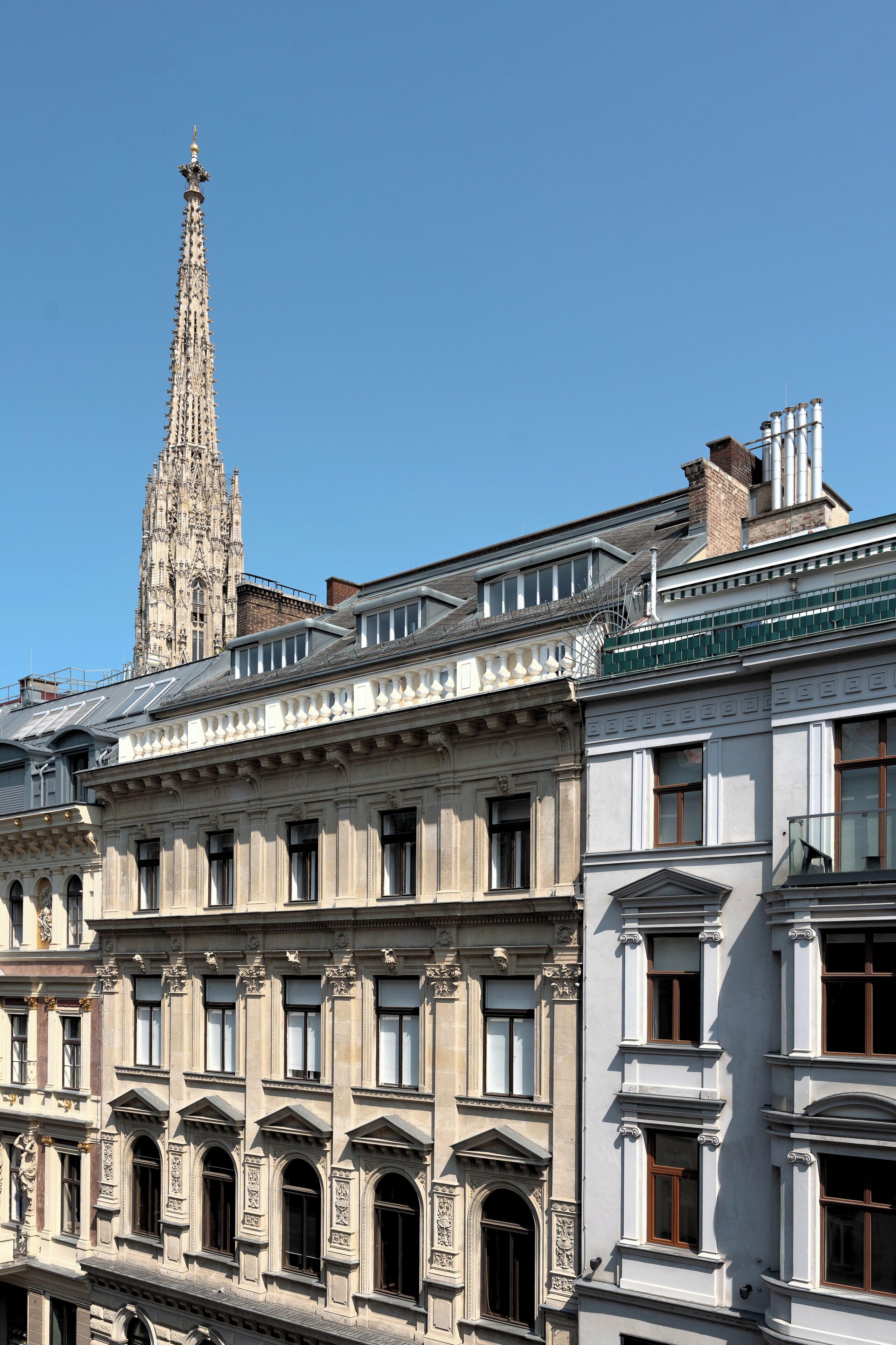 Um edifício histórico com detalhes arquitetônicos elaborados, incluindo uma agulha e várias janelas.
