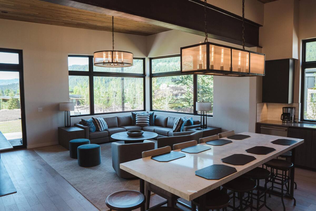 Cozinha moderna com uma ilha grande, assentos embutidos e amplas janelas que oferecem vista para o exterior.