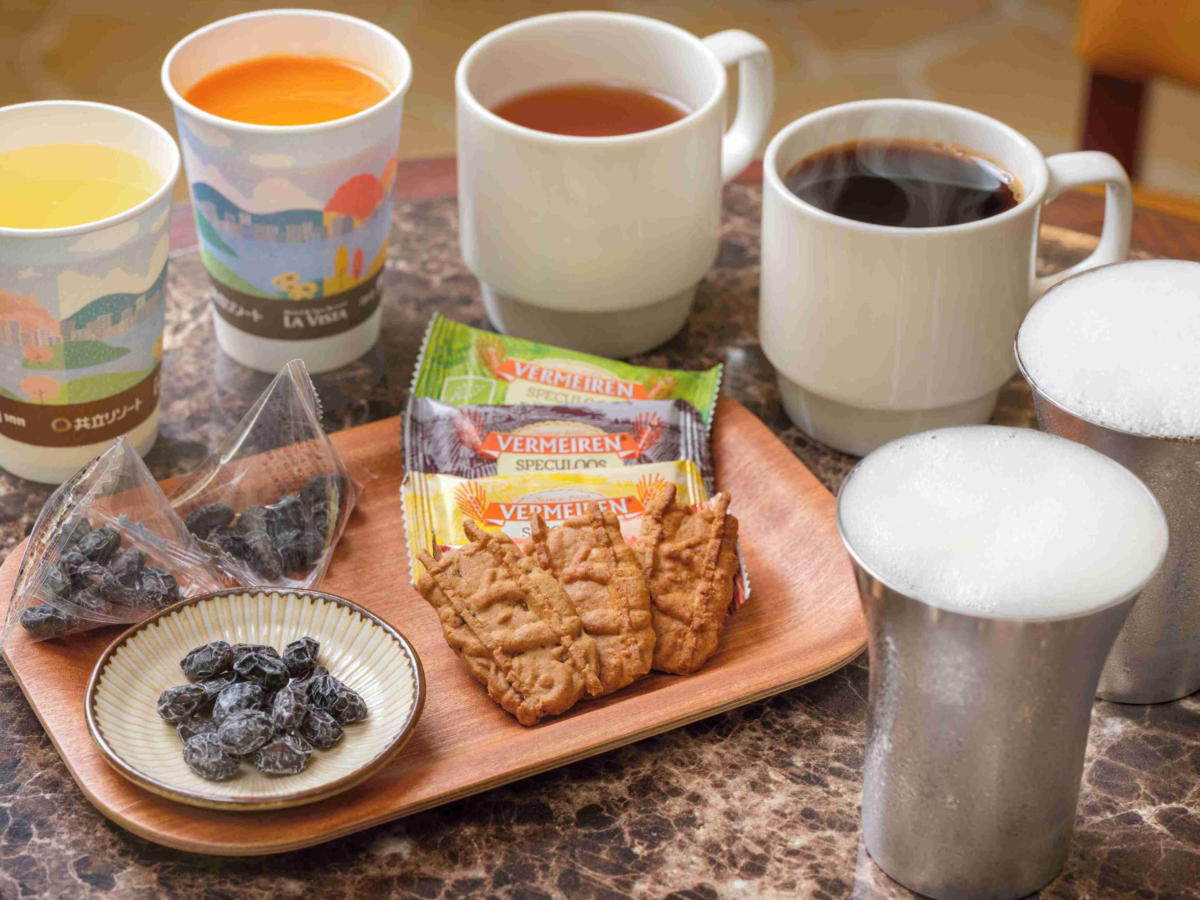 Uma mesa de café da manhã com diversas bebidas e petiscos.