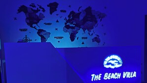 Mapa-múndi com uma bússola e o texto "THE BEACH VILLA" num fundo azul.