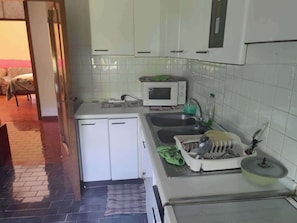 Um frigorífico, um micro-ondas, um forno, uma placa de cozinha