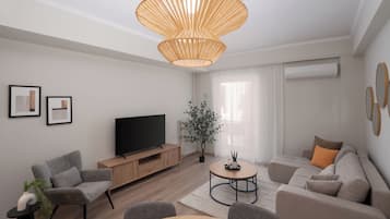 Apartamento superior, 2 quartos, sacada, vista para a cidade | Sala de estar | TV 50 polegadas com canais a cabo