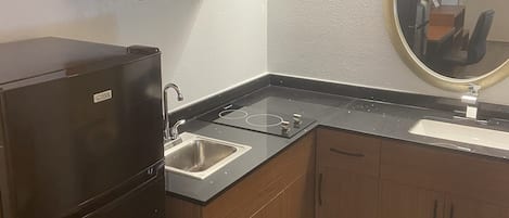Um frigorífico/congelador grande, um micro-ondas, uma placa de cozinha