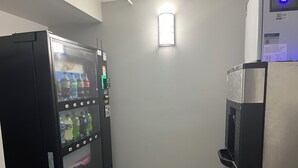Máquina de vendas com diversas bebidas e um frigorífico.
