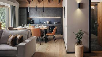 Um interior moderno com área de jantar, cozinha e sala de estar com sofá e planta.