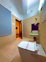 Casa de banho com chuveiro, espelho e lavatório.