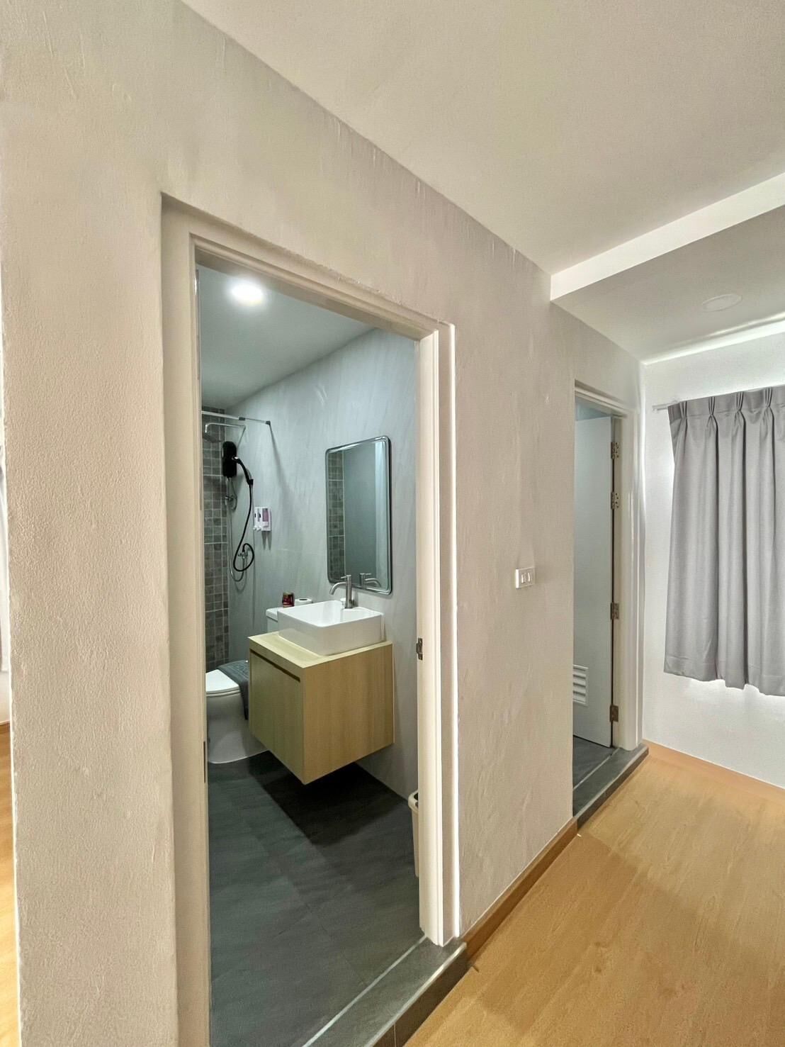 Uma casa de banho moderna com chuveiro, sanita e lavatório.