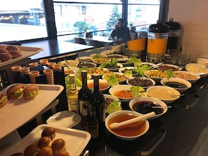Buffet com diversos alimentos e acompanhamentos.