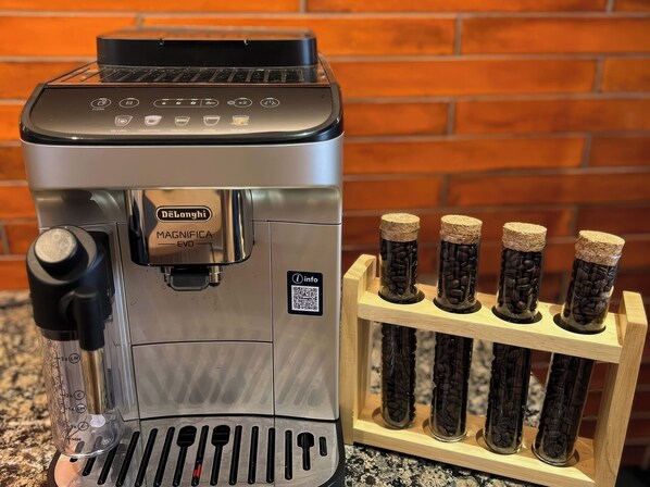Máquina de café expresso Delonghi Magnifica EVO com moedor integrado, um código QR e uma estante de madeira com grãos de café.