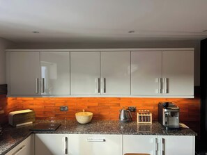 Uma máquina de lavar louça, utensílios de cozinha