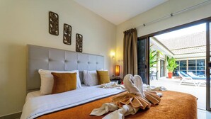 Quarto de hotel com uma cama grande, vista para a área da piscina e porta de vidro que dá para a piscina.
